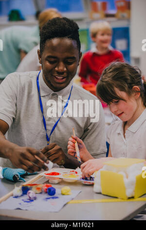 Young primary school student concentrating on writing in his notebook ...
