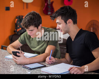 Two young friends doing homework with laptop computr and tablet PC ...