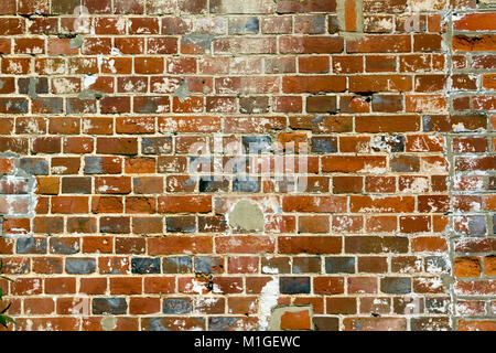Very old weathered, damaged, badly repaired hand made red brick wall ...