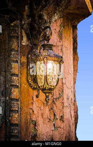 An ancient beautiful wall lamp hangs on the wall of the old building ...