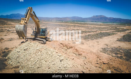 Aerial photo of earth moving machinery front loader digging a trench on ...