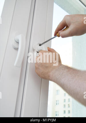 Worker with screwdriver installing window handle indoors Stock Photo ...