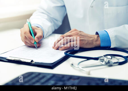 Doctor writing prescription in his office by stethoscope Stock Photo ...