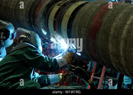 Workers welding sections of a submarine pipeline system using automatic ...