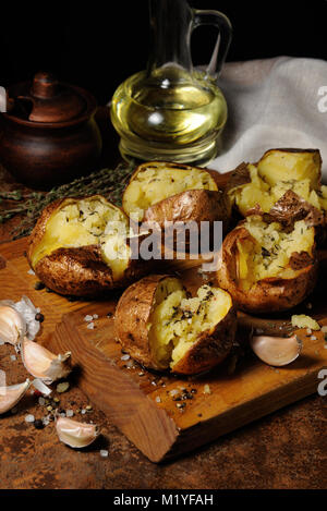 broken baked potato with spices and herbs on a wooden board Stock Photo ...
