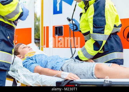 Emergency doctors putting injured boy in ambulance Stock Photo - Alamy