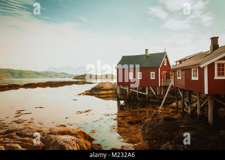 Typical red rorbu fishing hut by the fjord on Lofoten islands in Norway ...