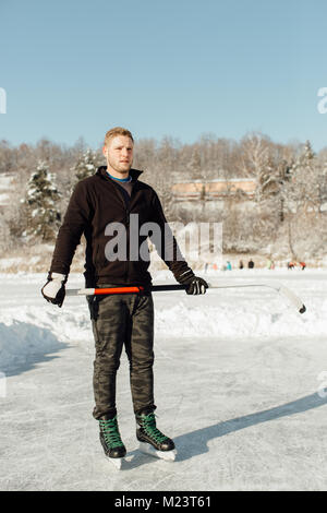 young man wearing ice skates on woman in winter hat Stock Photo - Alamy