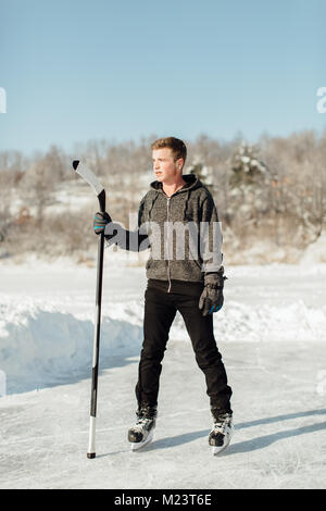 young man wearing ice skates on woman in winter hat Stock Photo - Alamy