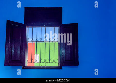 A typical Cuban window with a lattice and a view of the red-green wall ...
