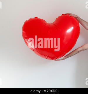 Hands holding a large inflatable heart shape Stock Photo - Alamy