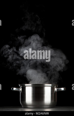 Steaming pot on black background Stock Photo - Alamy