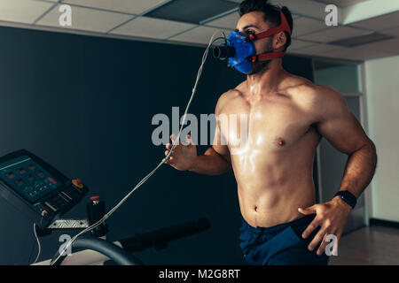 VO2 max test. Fit young man running fast on treadmill with a mask ...