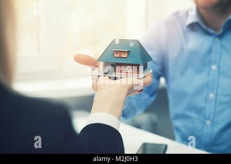 Real estate agent presenting house model during online meeting on ...