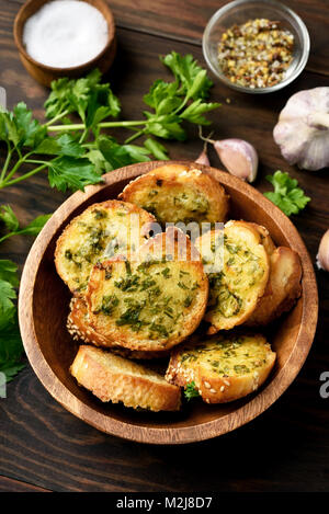 Plate of toasts with garlic and parsley on light background, closeup ...