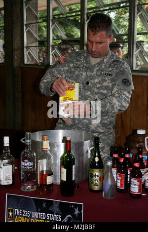 Lt. Col. Rocky Burrell adds his ingredient to the grog during the Army ...