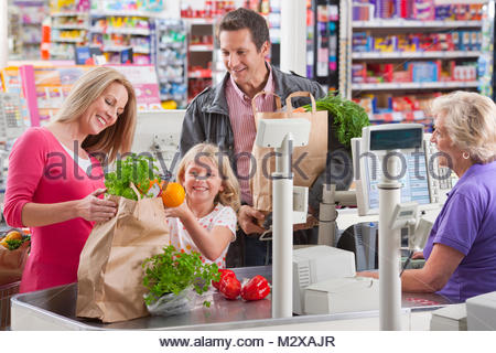 Family packing shopping at supermarket checkout Stock Photo: 127468069 ...