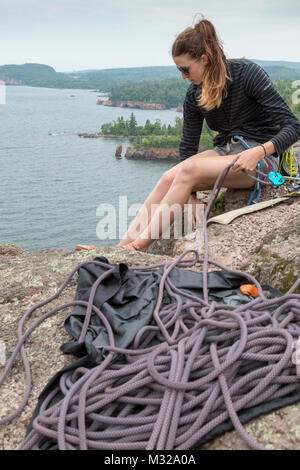 Silver Bay, Minnesota - A rock climber carries climbing ropes near ...
