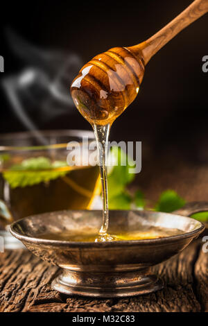 Honey and honey dipper on green and white checked cloth in flat lay ...