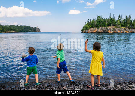 Three children throwing rocks into a lake, Split Rock Lighthouse State ...