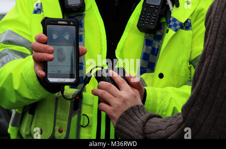 A West Yorkshire Police officer holding a new mobile fingerprint ...