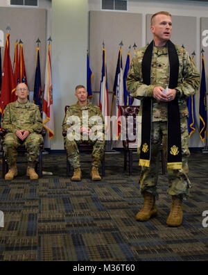 Army Chaplain Lt. Col., William O. Barefield, second from left, bows ...