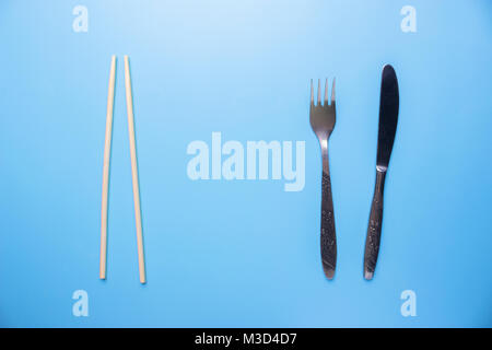 Chopsticks and a fork on the mat. Choice concept Stock Photo - Alamy