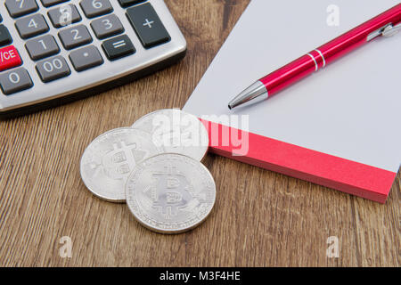 Bitcoins, calculator and notes on a wooden table Stock Photo - Alamy
