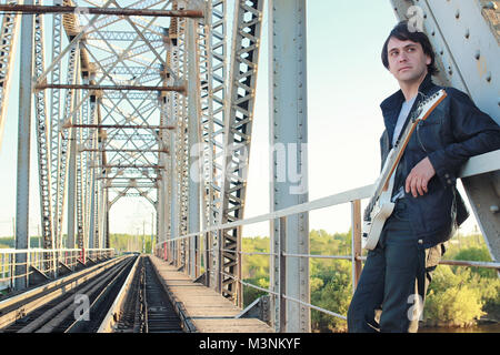Man with an electric guitar in the industrial landscape outdoors Stock ...