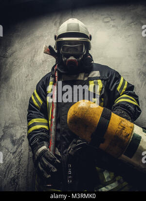 Fireman in fireproof uniform and helmet flexing his biceps Stock Photo ...