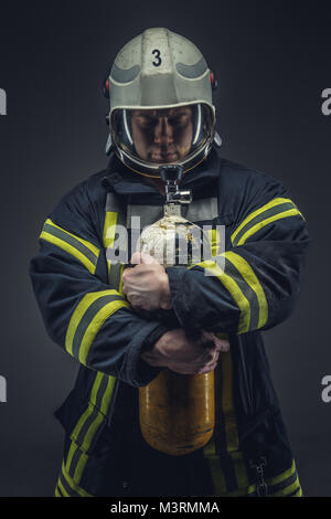 A firefighter wearing a protective suit and an oxygen breathing ...