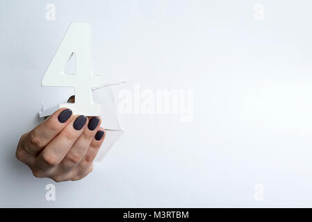 Female hand holds the figure four white isolated background. Copy Space ...