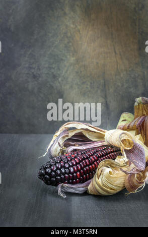 fresh organic purple corn cob with leaves on a wooden background Stock ...