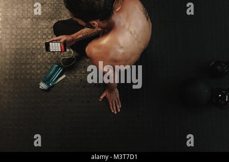 Checking on his progress. A muscular bodybuilder flexing his muscles ...