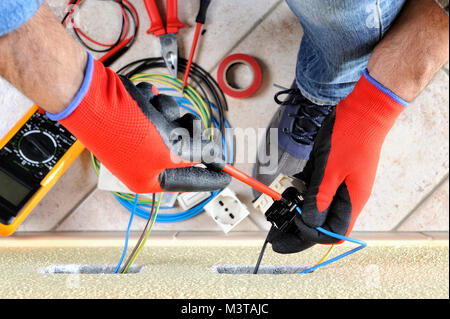 Electrician technician at work blocks the cable between the clamps of a ...