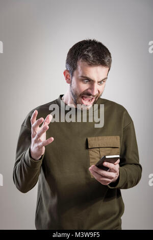 Man angry at his phone, outraged and enraged Stock Photo - Alamy