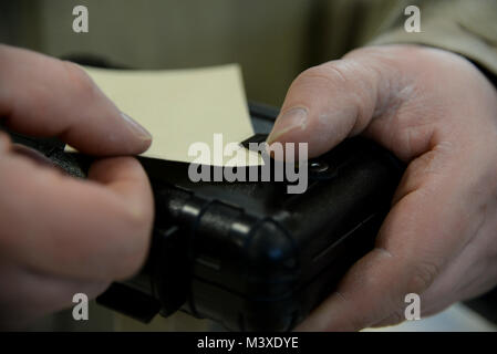 An Airman affixes M8 chemical detection paper to a stanchion during a ...