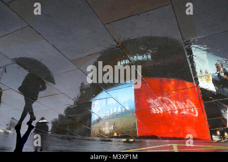 Coca cola advertisement reflected in a puddle at Piccadilly Circus ...