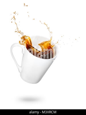 Falling and spilling of a cup of coffee on top of a desk with an open ...