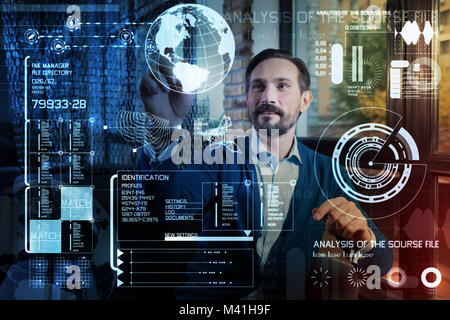Looking at the screen. Experienced programmer standing in front of a ...
