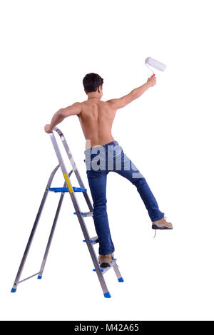Handsome workman on ladder painting wall in white with paintbrush Stock ...