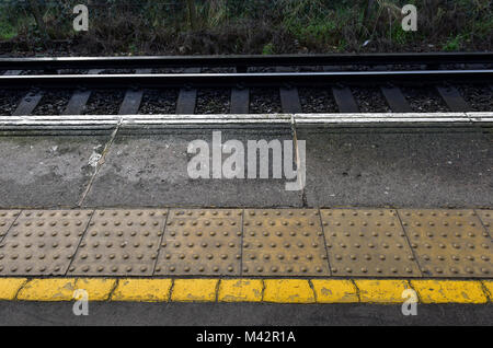 tactile slabs or coping stones on the edge of a platform at a mainline ...