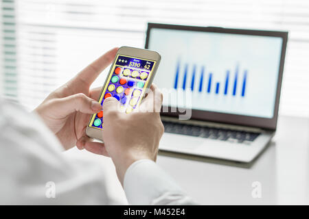 Lazy office worker playing mobile game with smartphone during work ...