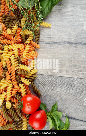 Raw eliche and penne tricolori pasta in the wooden bowls on the table ...