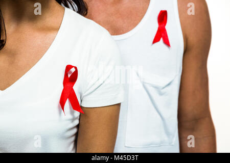 Midsection of people with red ribbon on clothes Stock Photo - Alamy