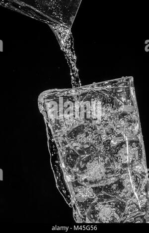 sparkling water overflow over ice cubes Stock Photo - Alamy