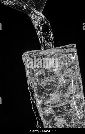 sparkling water overflow over ice cubes Stock Photo - Alamy