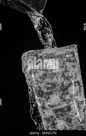 sparkling water overflow over ice cubes Stock Photo - Alamy