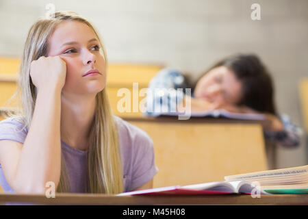 Bored student listening while classmate sleeping Stock Photo - Alamy