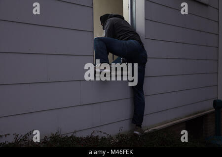 Man entering into a building through the window Stock Photo - Alamy